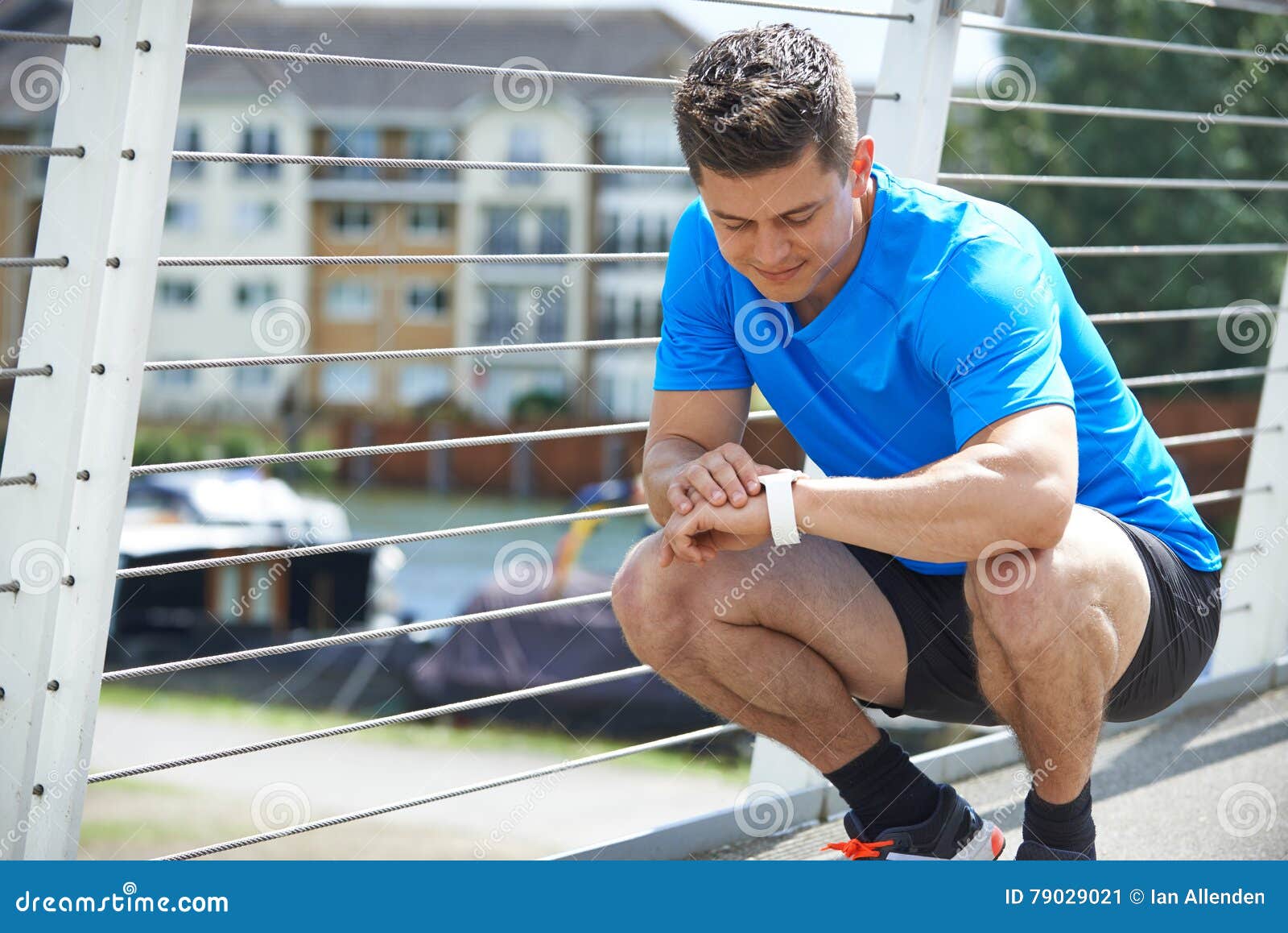 Man Looking at Activity Tracker Whilst Exercising in City Stock Image ...