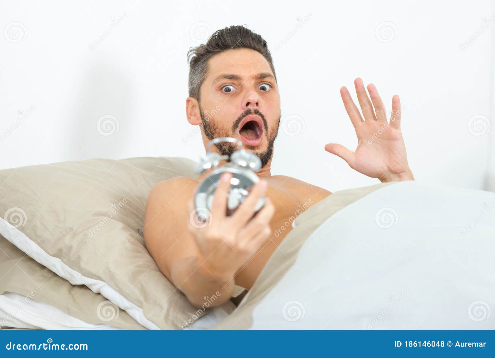 Man Looking at Alarm Clock with Shocked Expression Stock Photo - Image ...