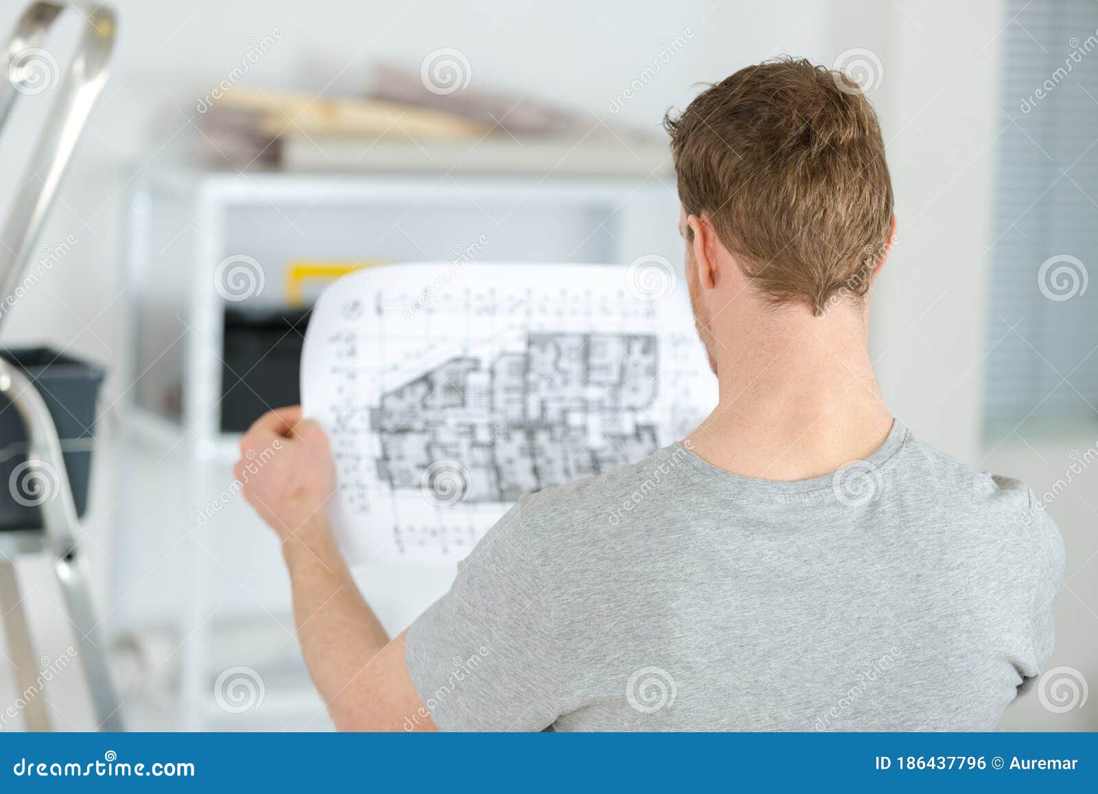 Man looking at blueprint stock photo. Image of document - 186437796