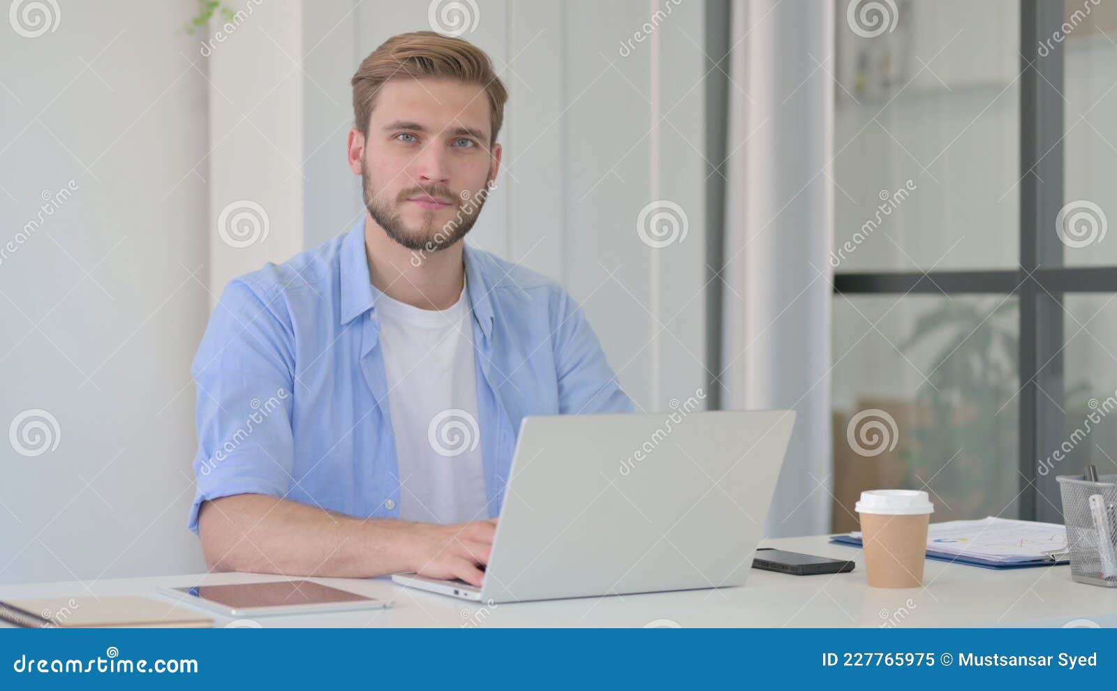 Man Looking at Camera while Using Laptop in Office Stock Image - Image ...