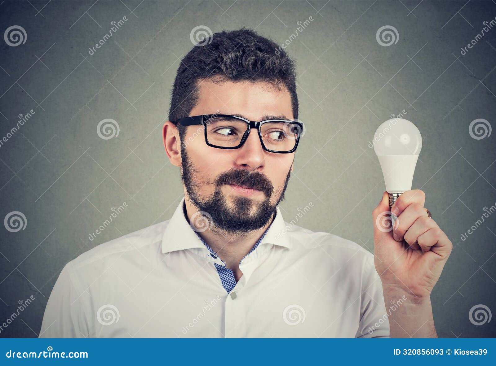 Man in Glasses Looking at an Energy Efficient Light Bulb Stock Image ...