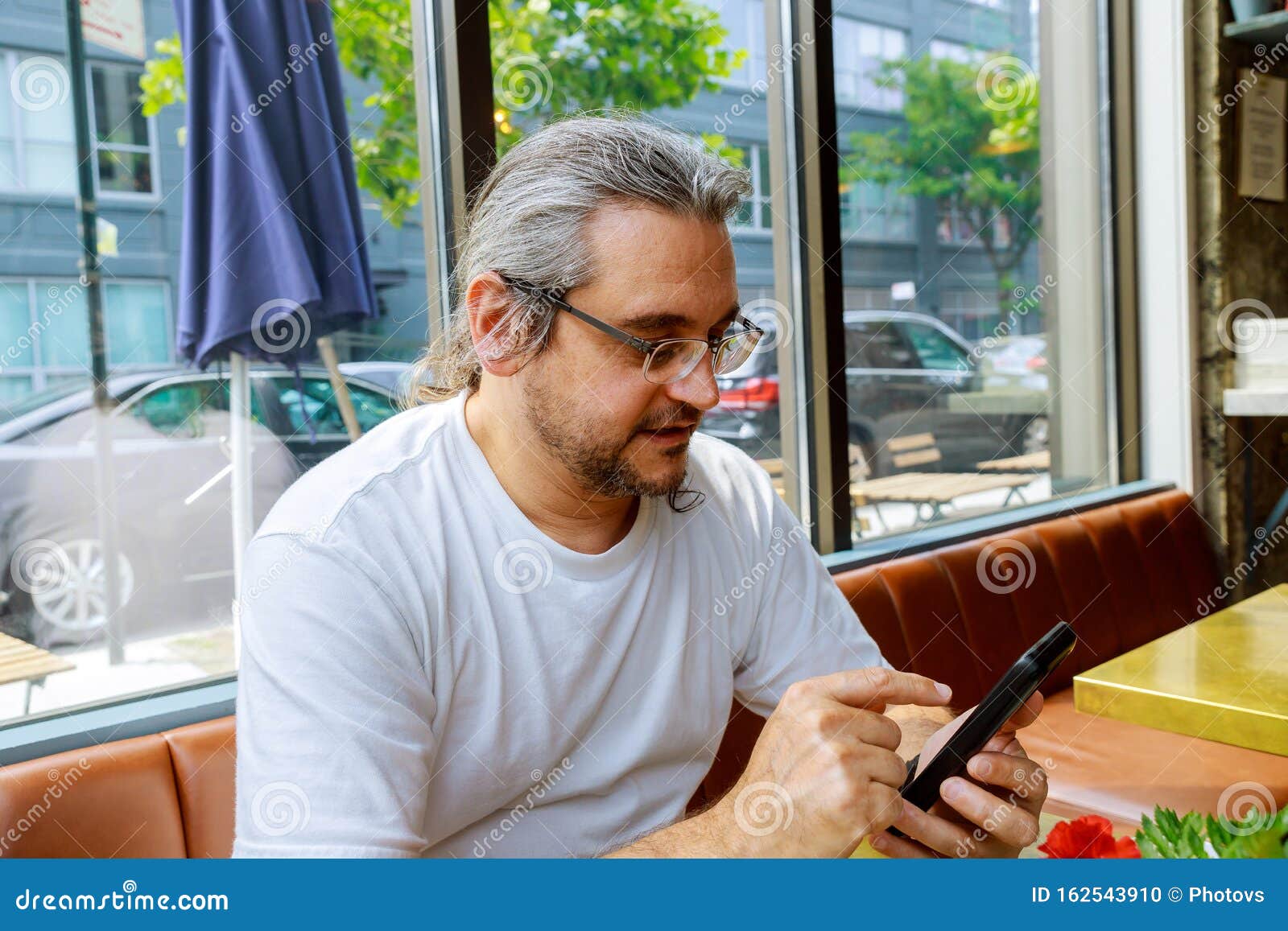 Man Looking at His Hands with Smartphone Texting Message or Dialing ...