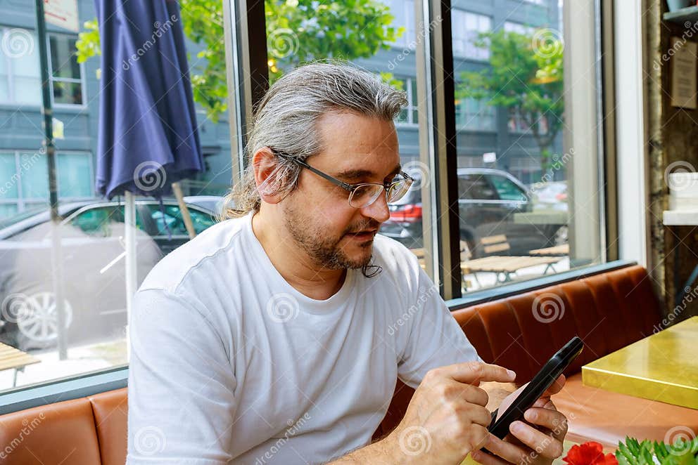 Man Looking at His Hands with Smartphone Texting Message or Dialing ...