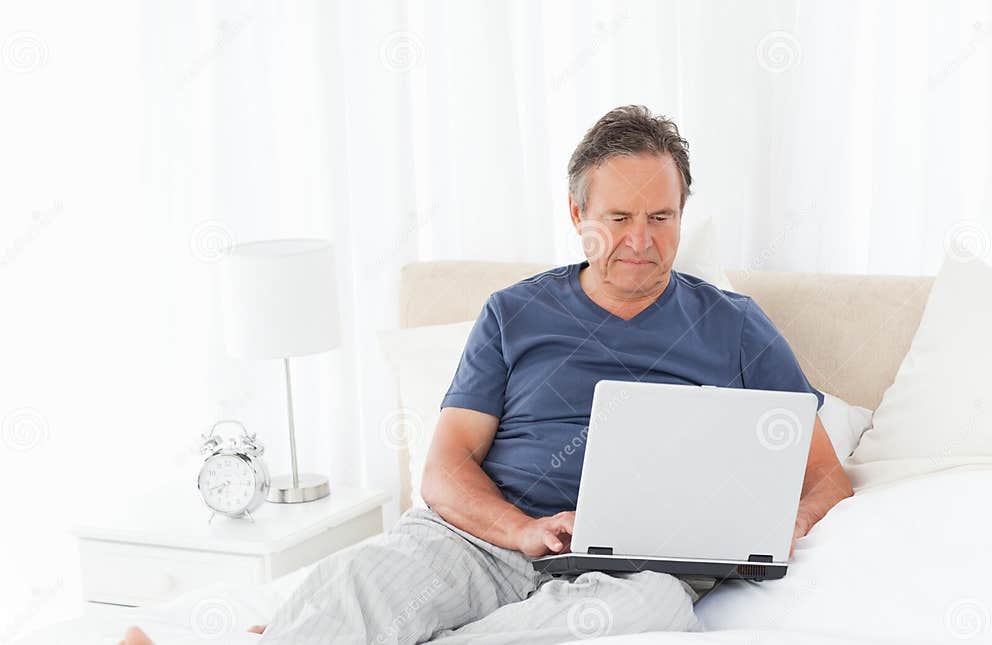 Man looking at his laptop stock photo. Image of male - 18109440