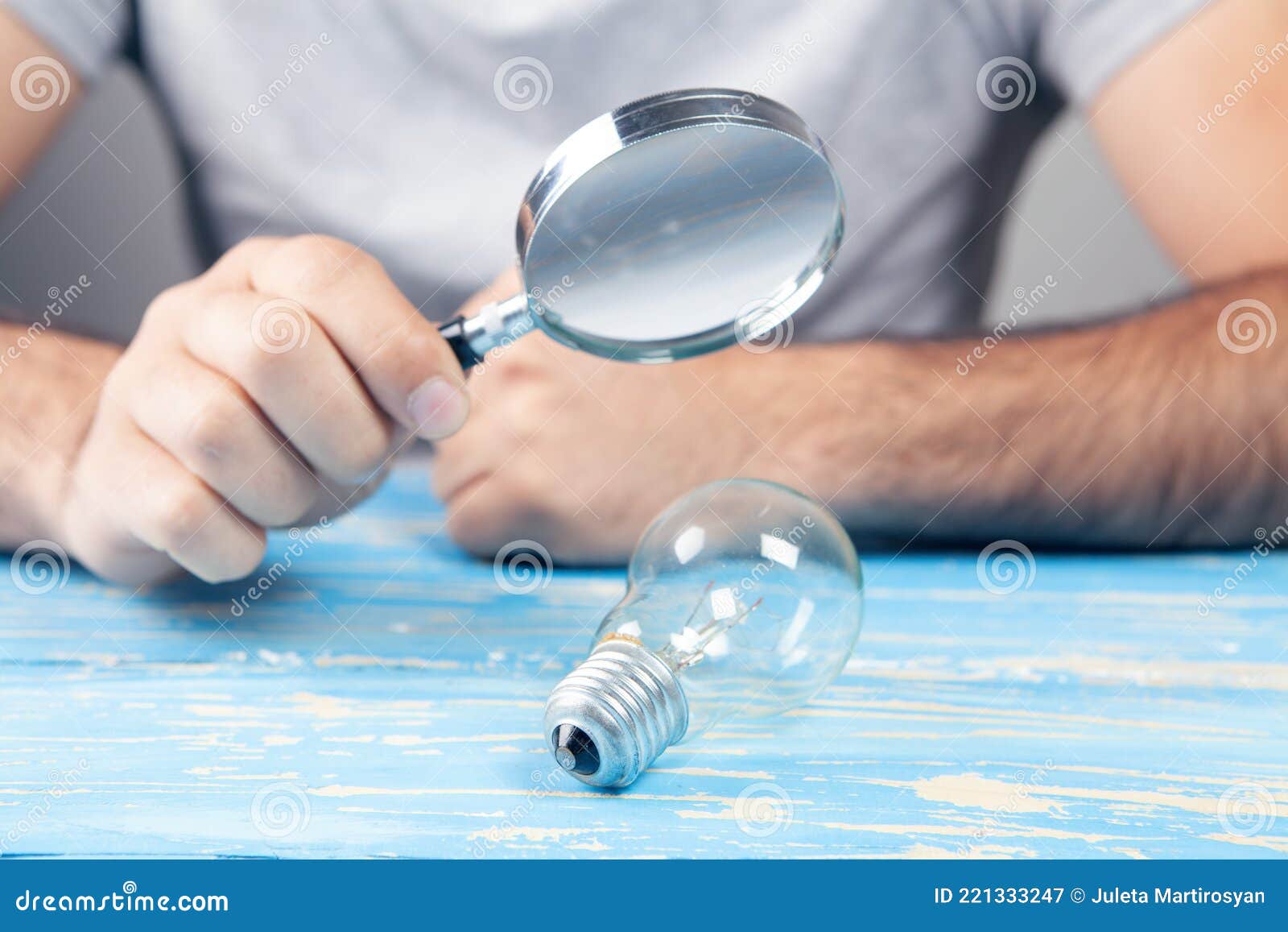 A Man Looking at a Light Bulb with a Magnifying Glass Stock Image ...