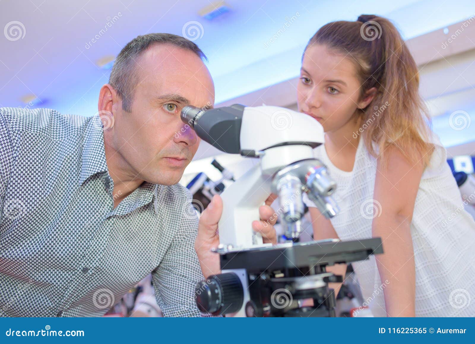 Man Looking through Microscope Young Lady Watching Stock Image - Image ...