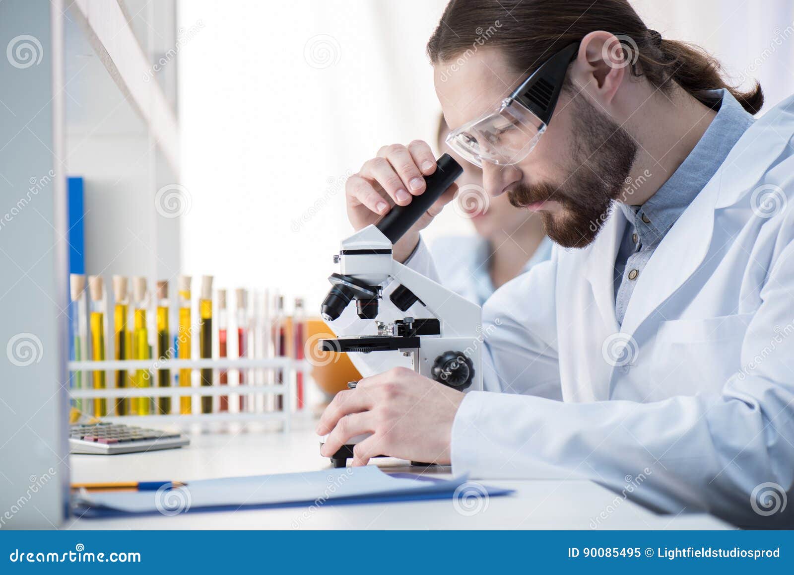 Man looking in microscope stock image. Image of science - 90085495