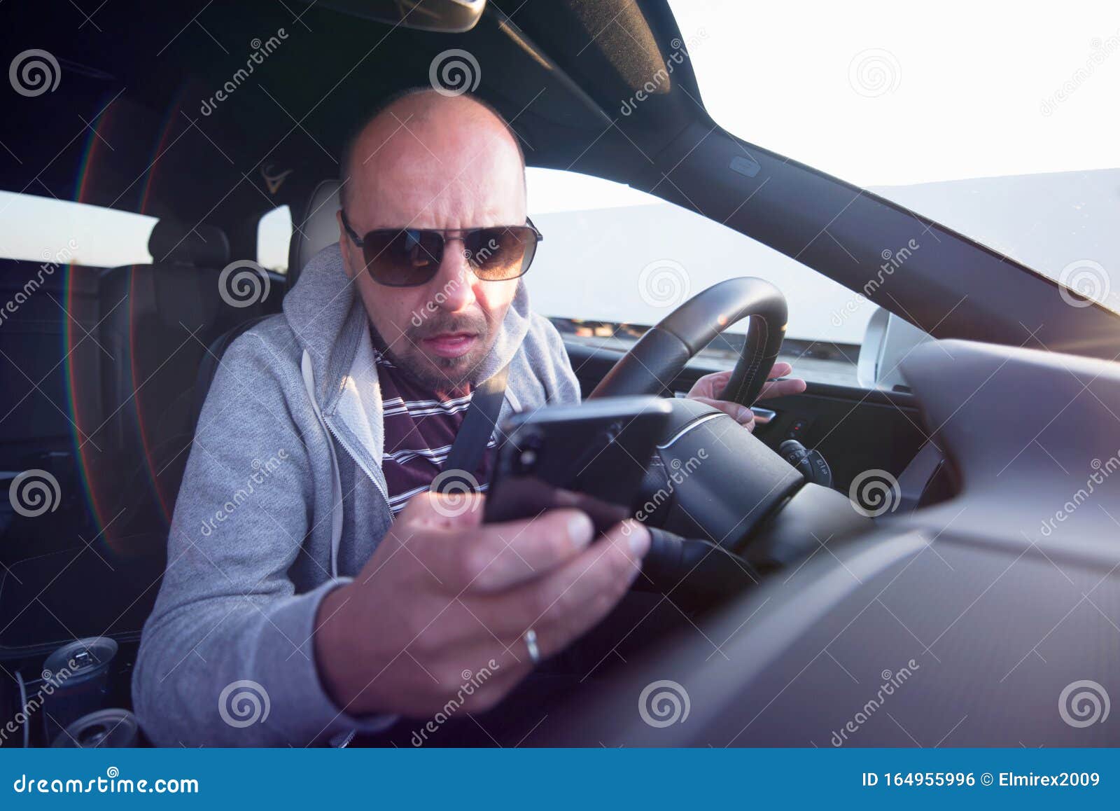 Man Looking at Mobile Phone while Driving a Car Stock Photo - Image of ...