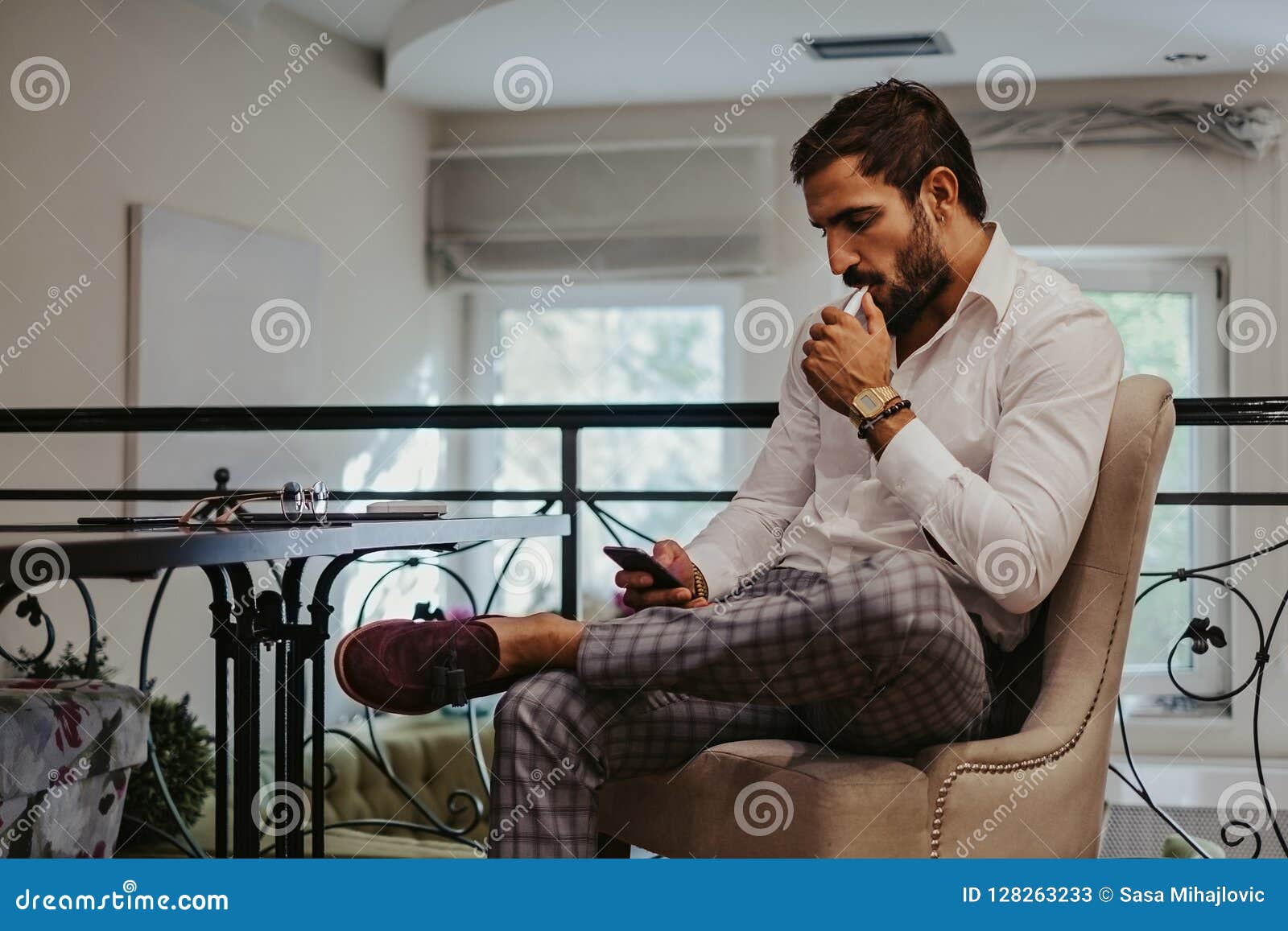 Man Looking at Mobile Phone and Smoking Electronic Cigarette Stock ...