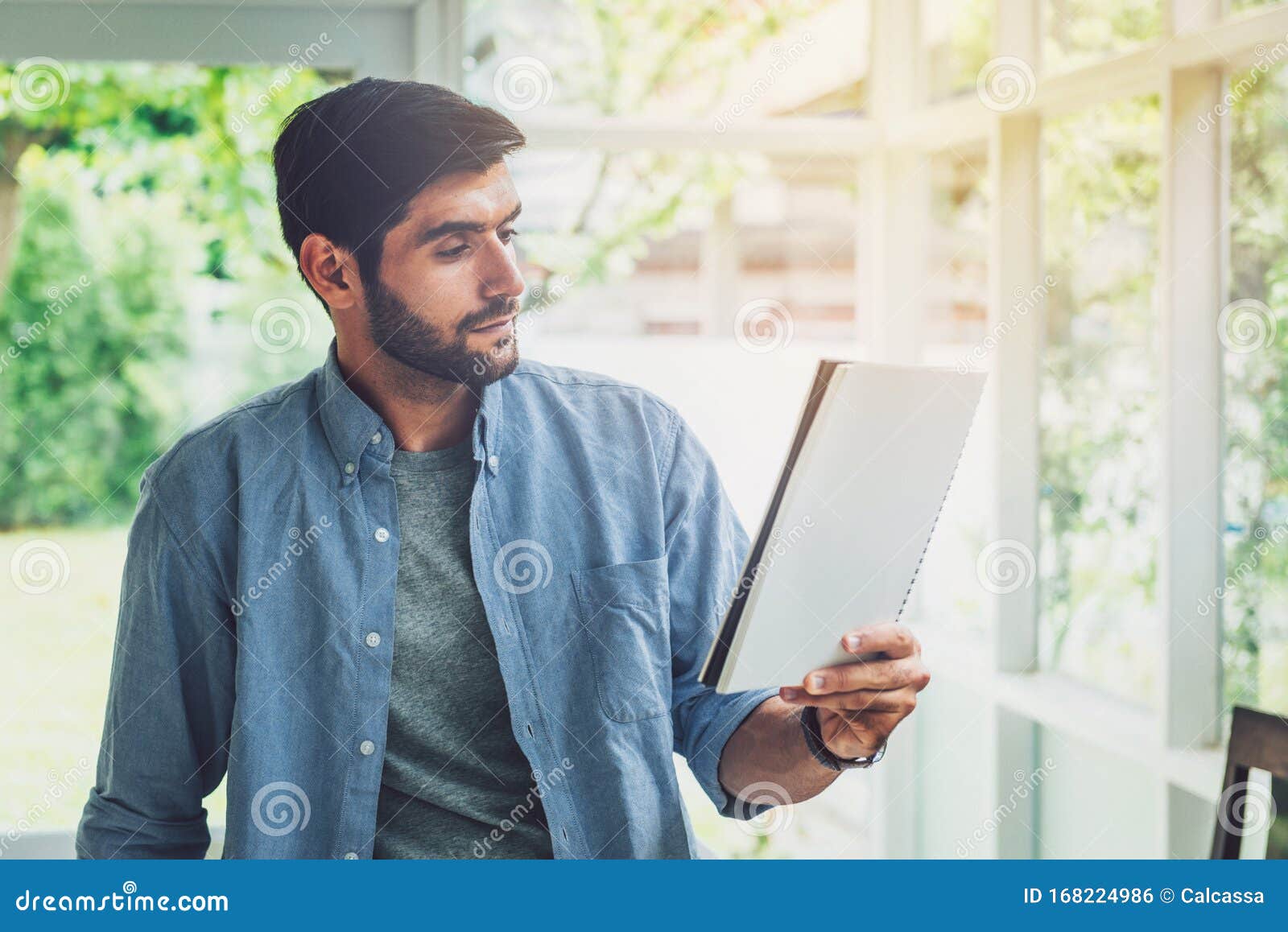 A Man Looking at Paper Note while Working Stock Photo - Image of ...