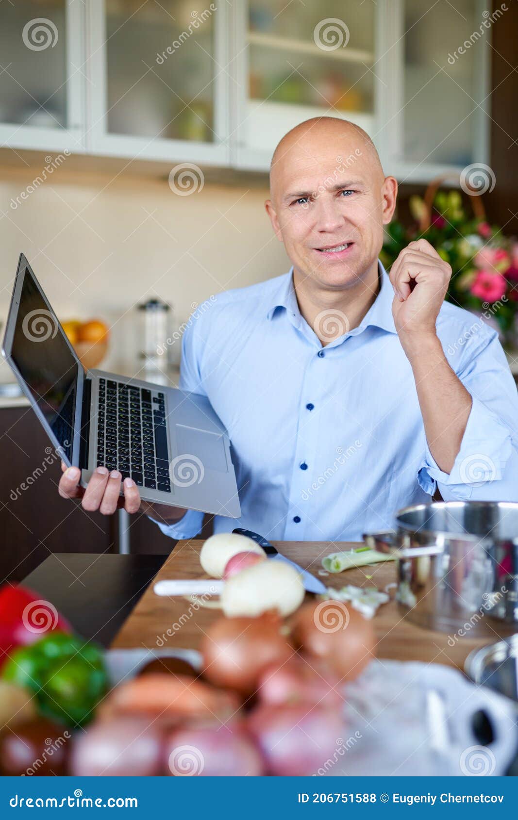 Man Looking at Recipe in Laptop while Cooking Dinner. Stock Photo ...