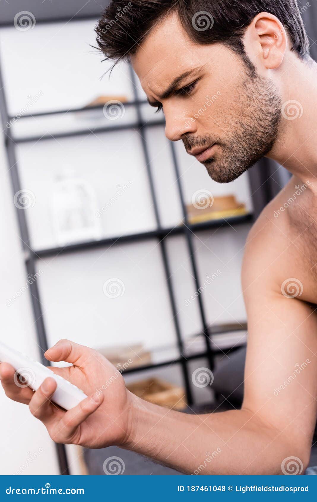 Man Looking at Remote Controller from Stock Photo - Image of muscular ...
