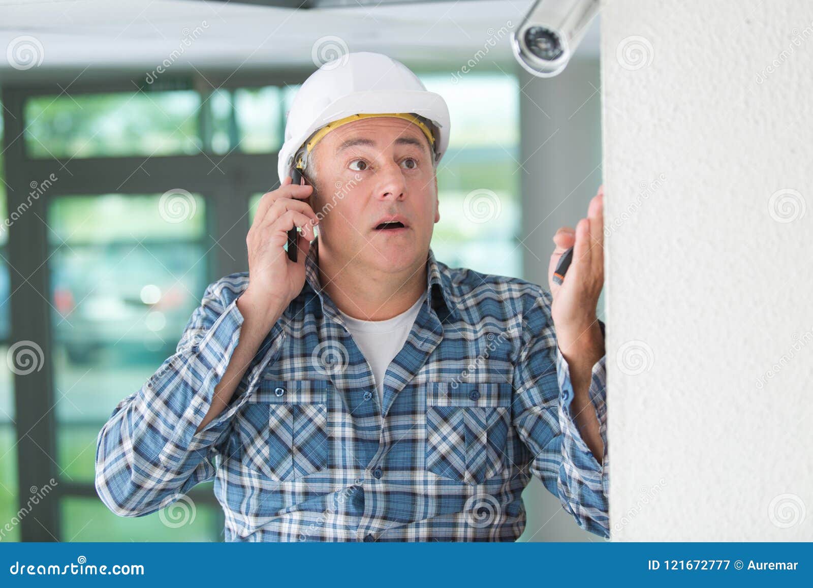 Man Looking at Security Camera and Making Phonecall Stock Image - Image ...