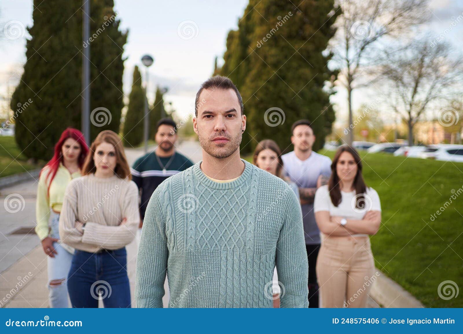 Man Looking Serious at the Camera while Standing in Front of a Group of ...