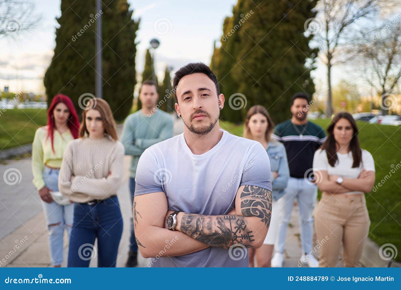 Man Looking Serious at the Camera while Standing in Front of a Group of ...