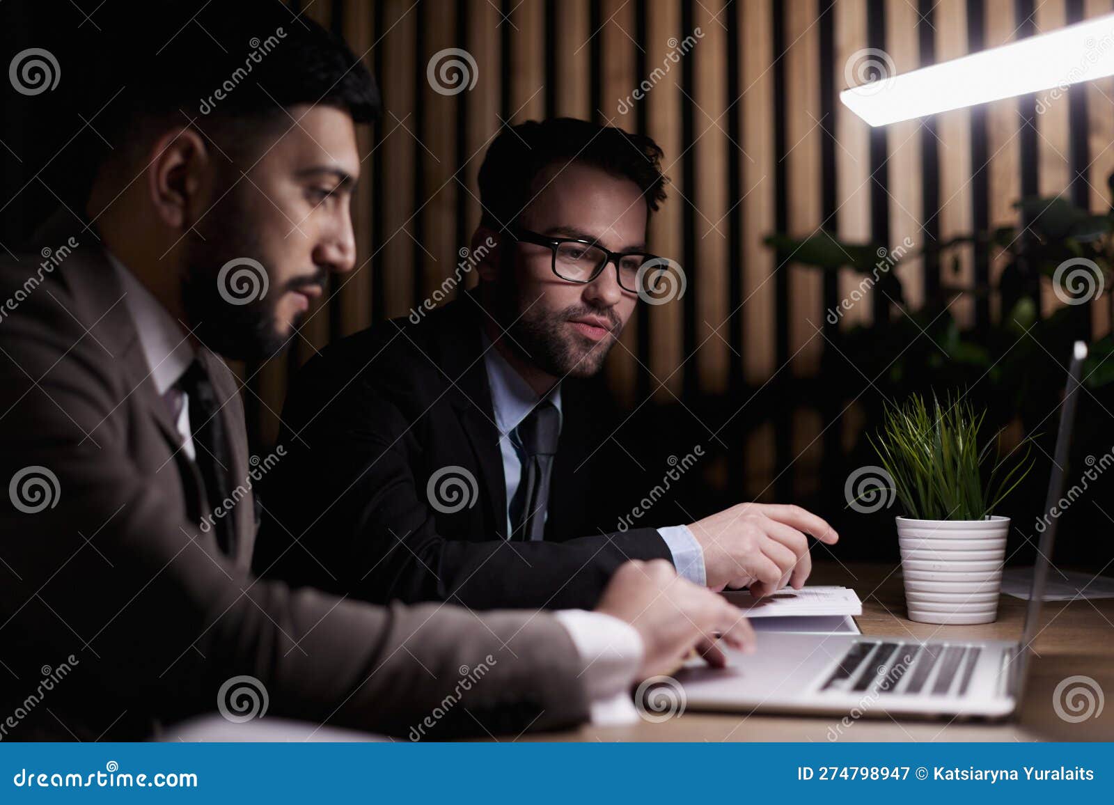 Side View of Computer Systems Analysts Using Charts on Computer ...