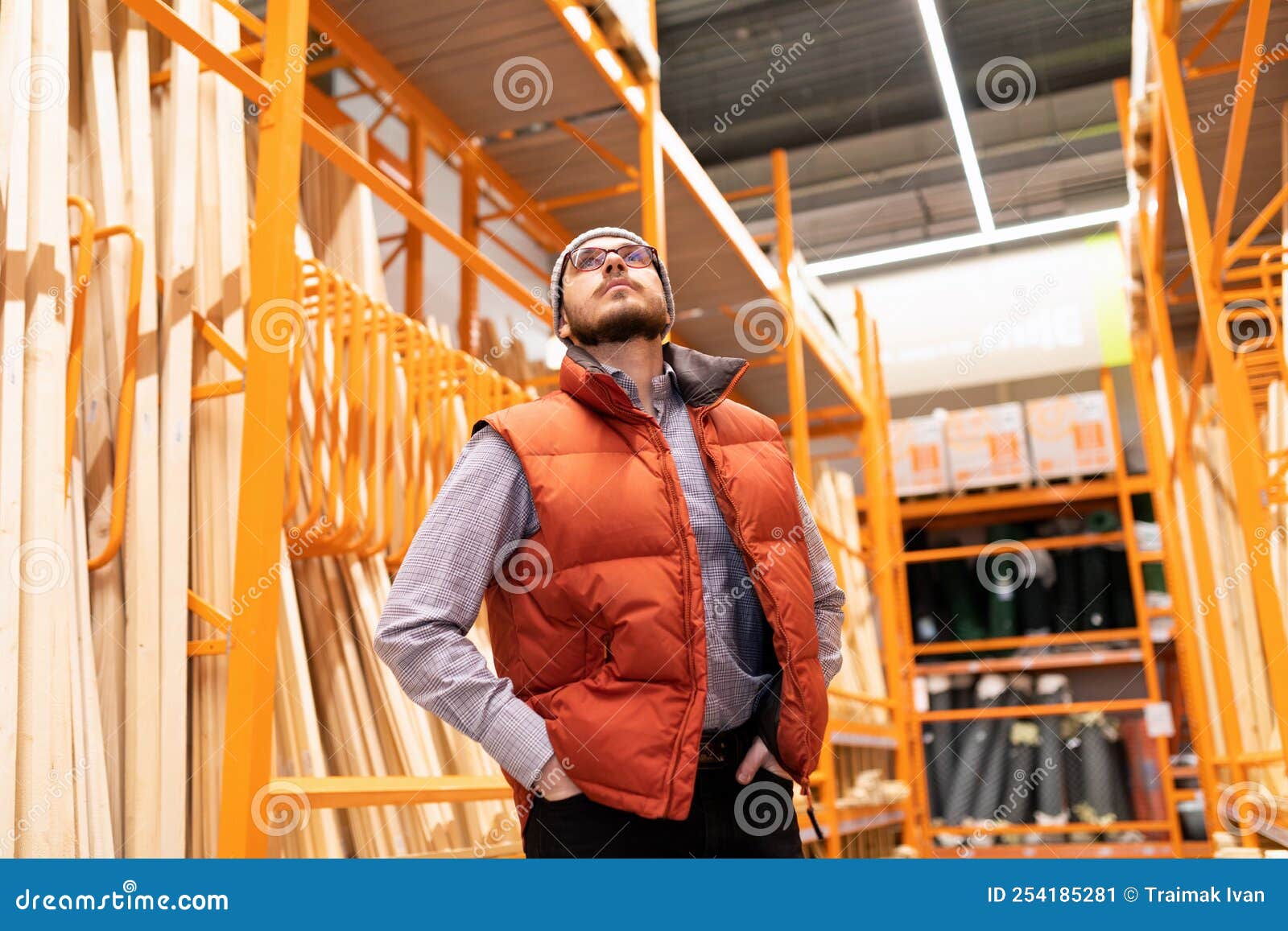 A Man in a Lumber Store Examines the Assortment while Looking at the ...