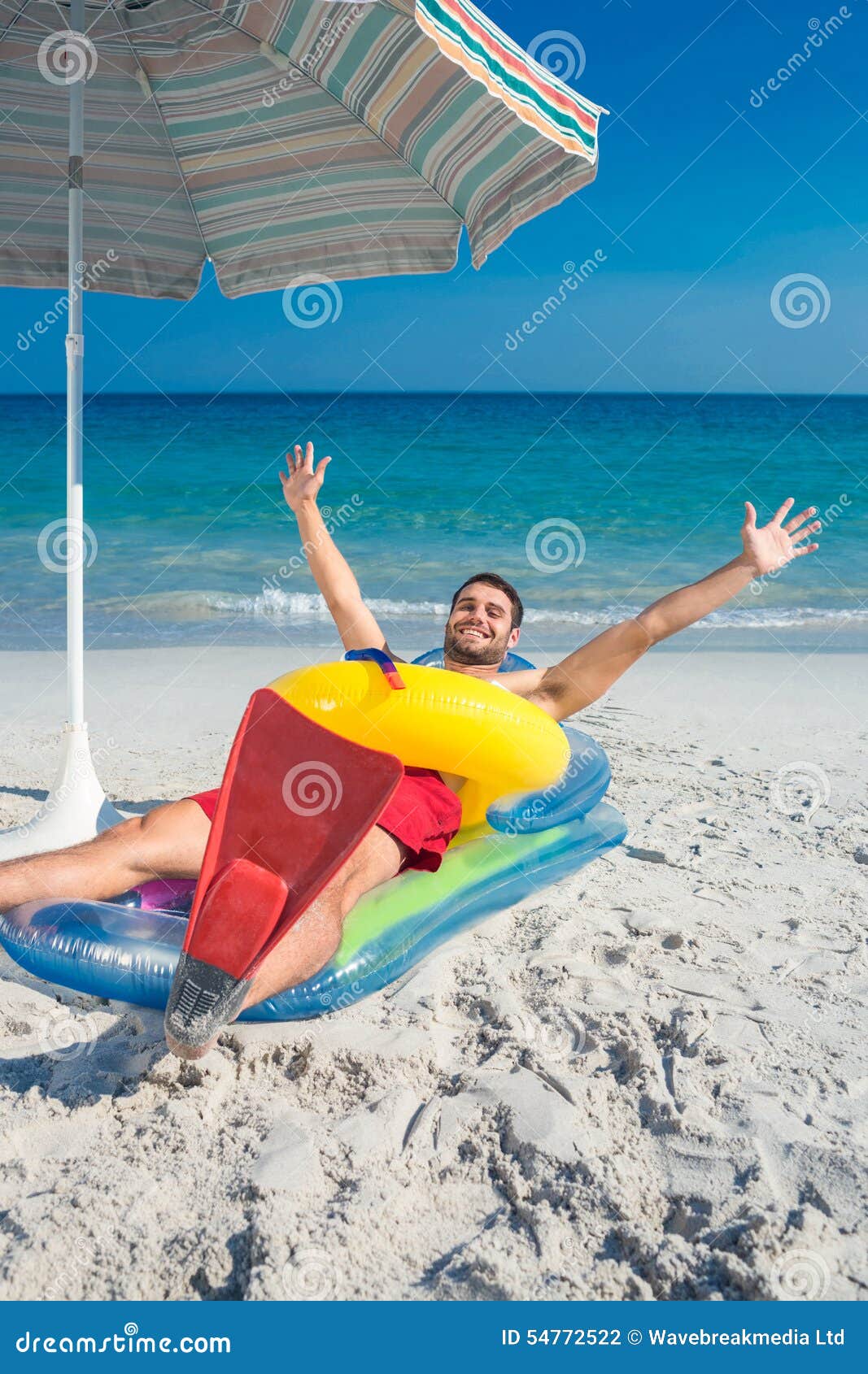 Man Lying on the Beach with Flippers and Rubber Ring Stock Photo ...