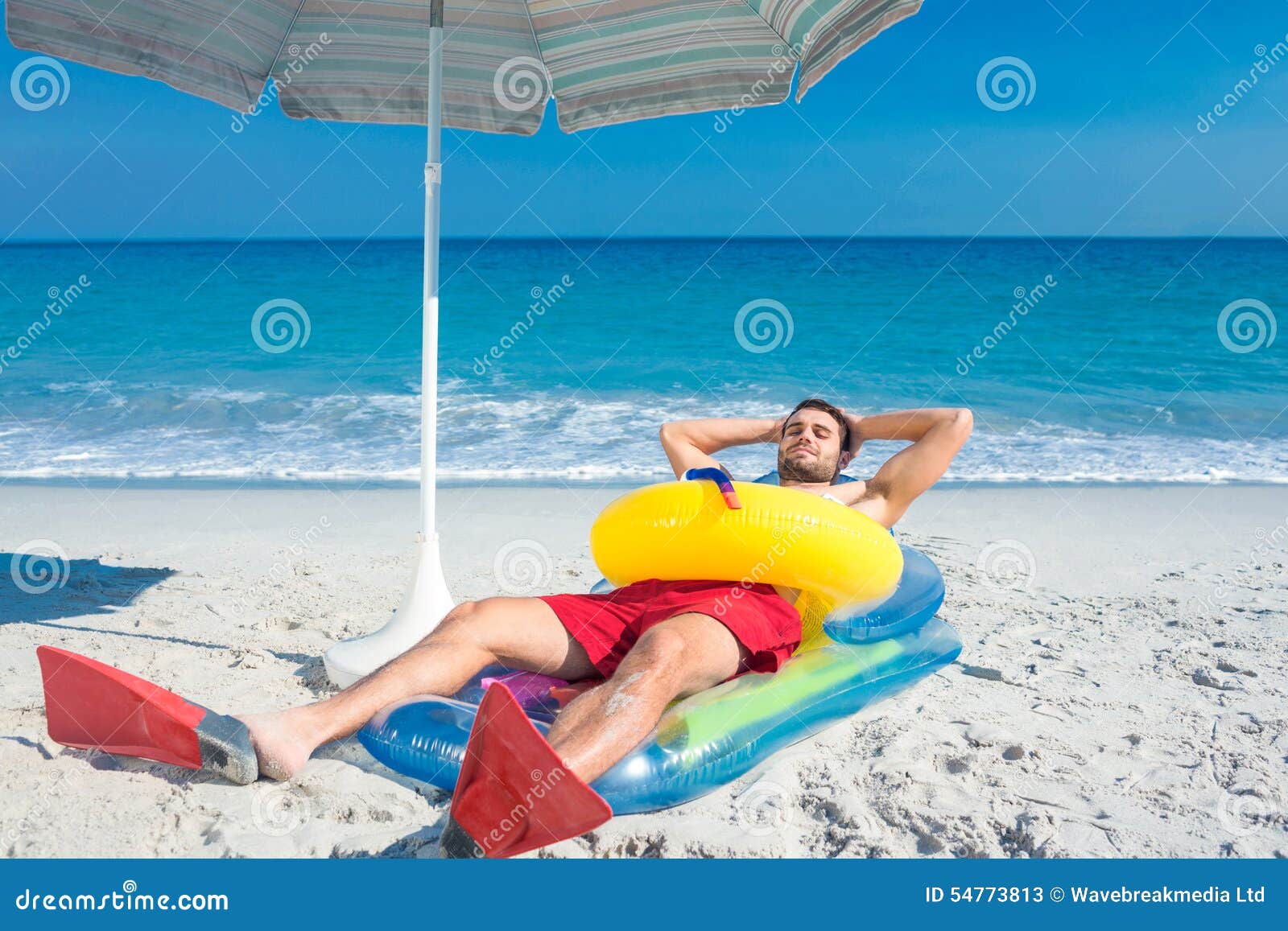 Man Lying on the Beach with Flippers and Rubber Ring Stock Image ...