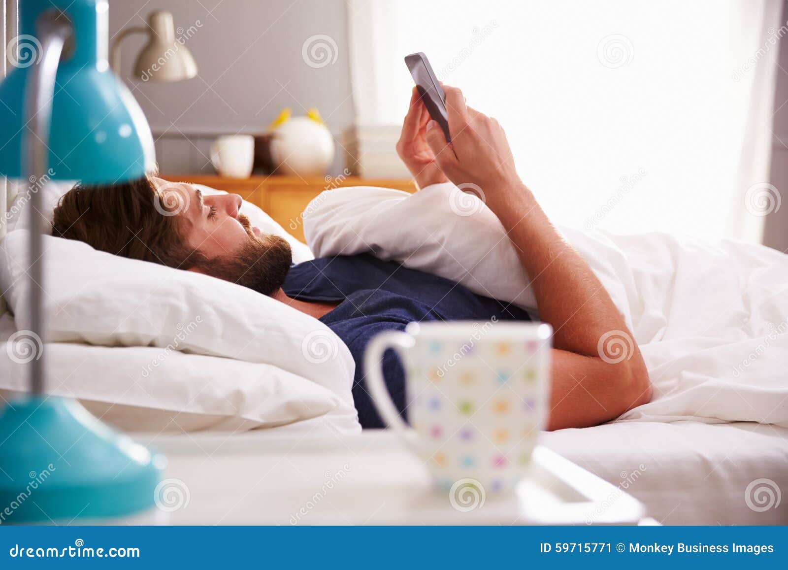 Man Lying in Bed Checking Mobile Phone Stock Image - Image of life ...