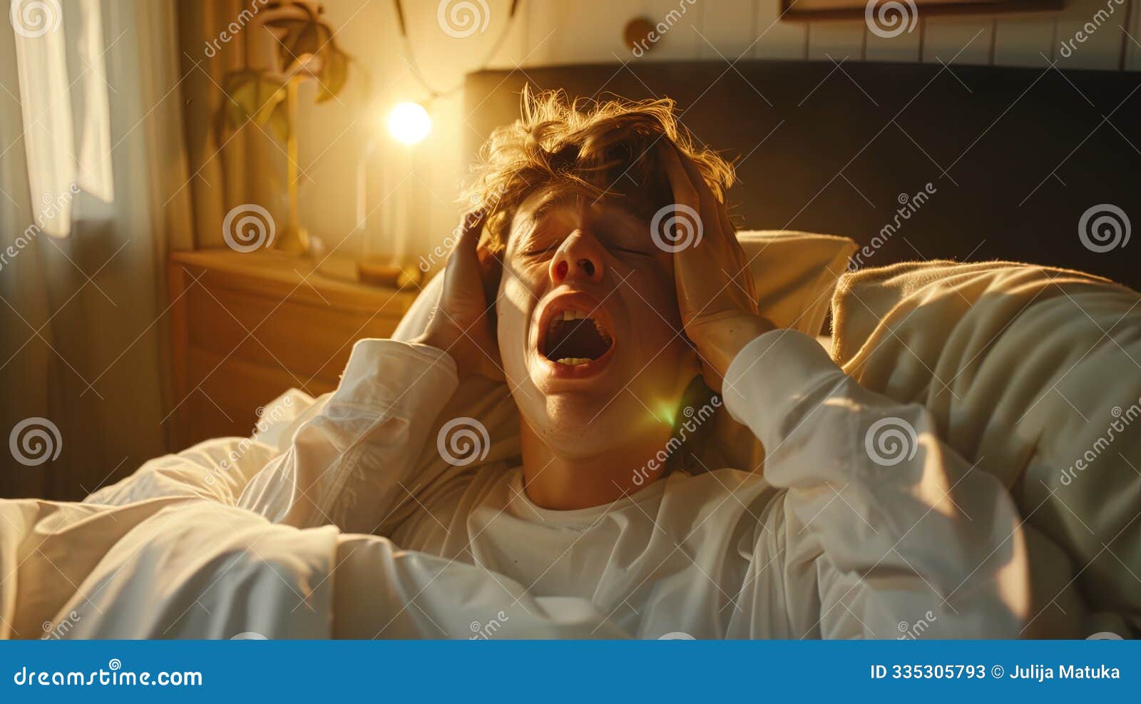 A Man is Lying in Bed, Screaming and Holding His Mouth Open Stock ...