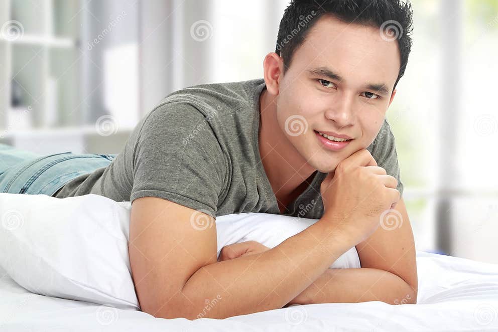 Man lying in bed smiling stock image. Image of person - 23959619