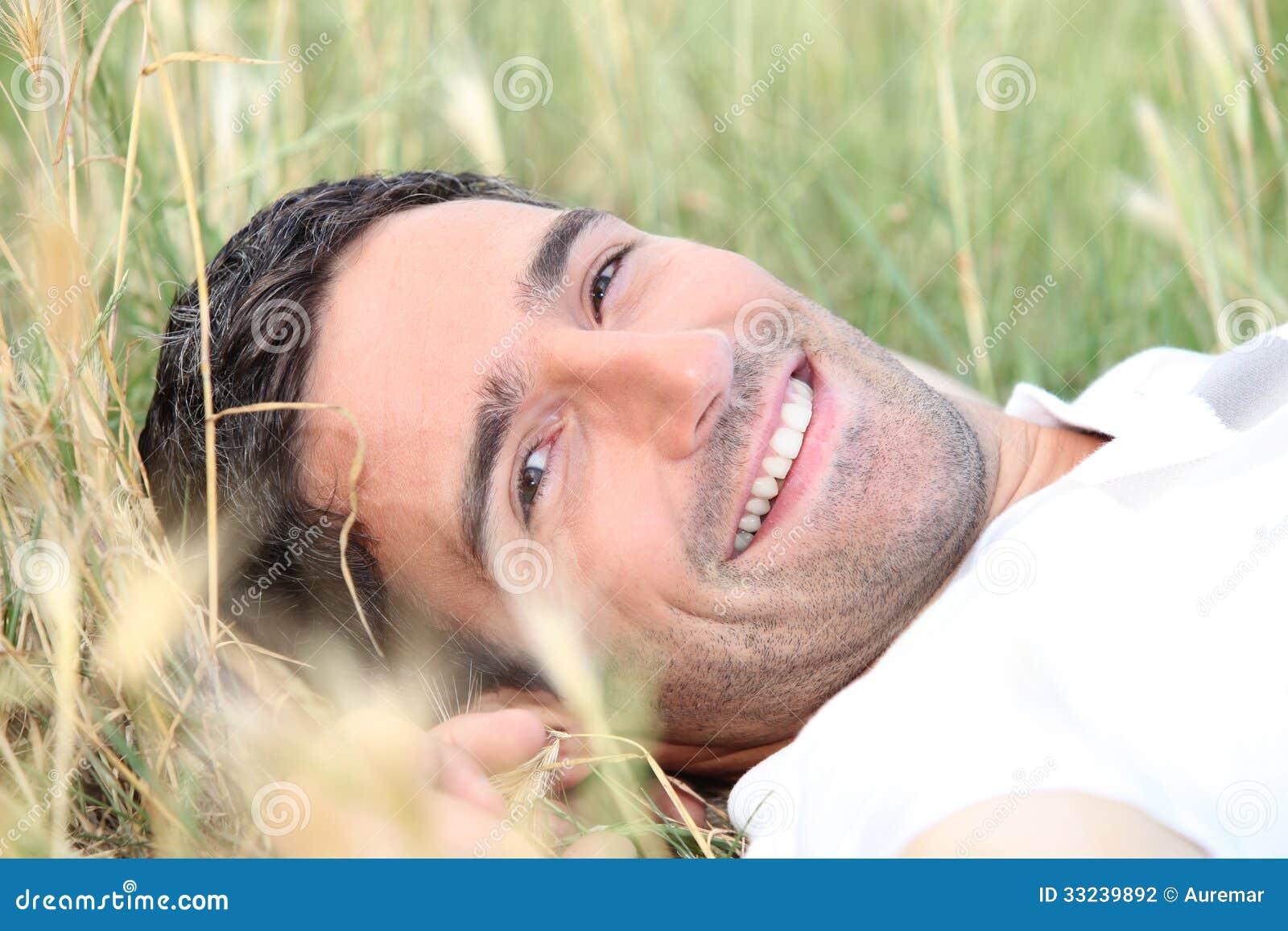 Man lying down in a field stock photo. Image of shirt - 33239892