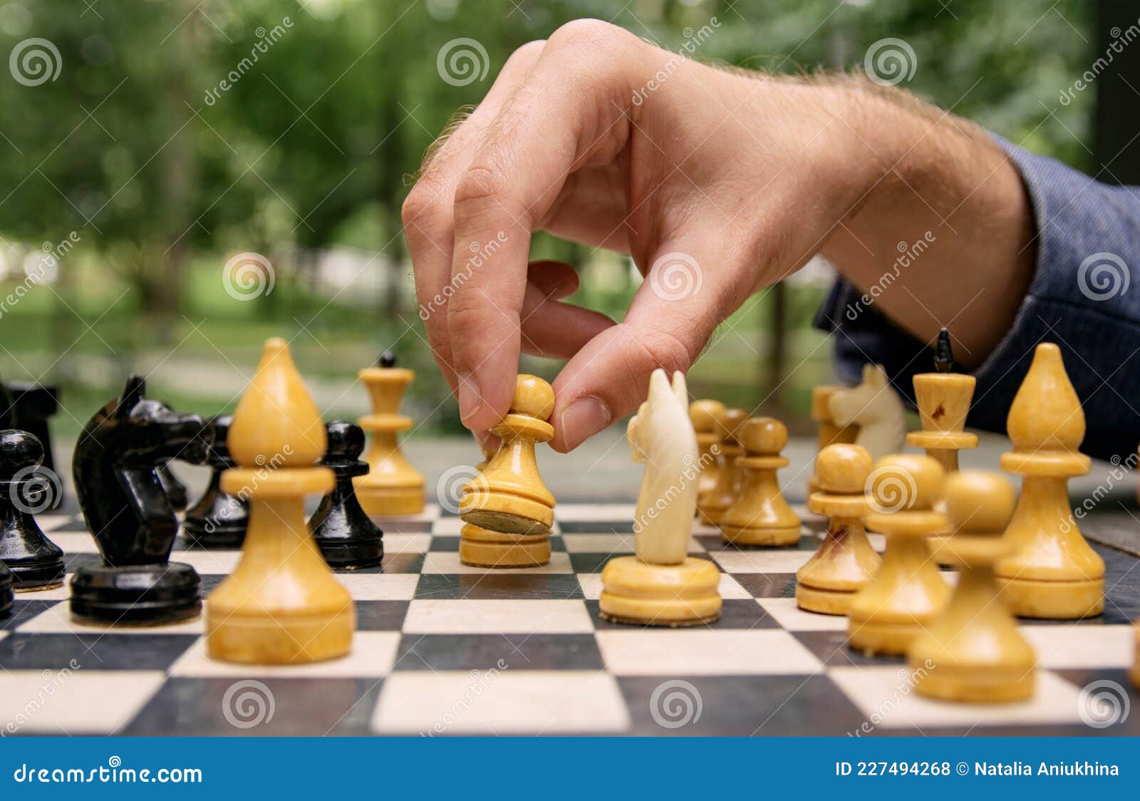 A Man Makes a Move with a Chess Piece of a White Pawn Side View on a ...