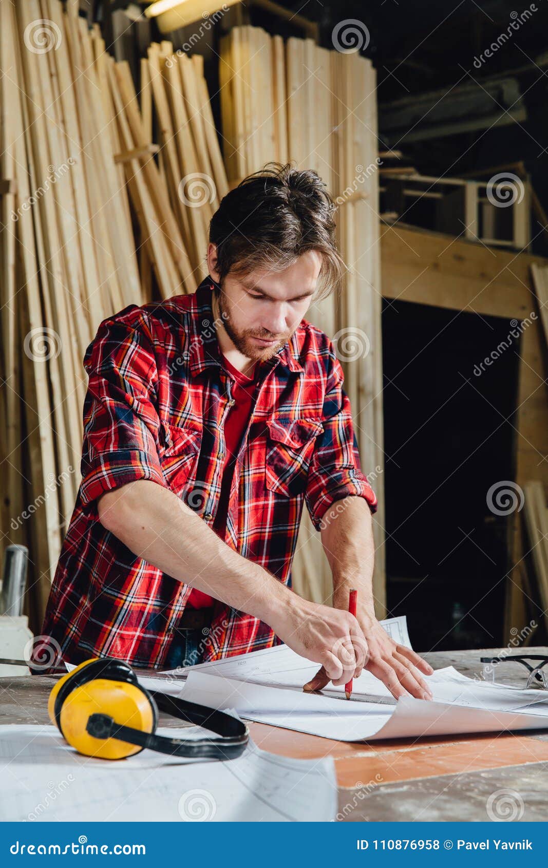 Man Making Draft Plan Using Pencil on the Table with Workshop on ...