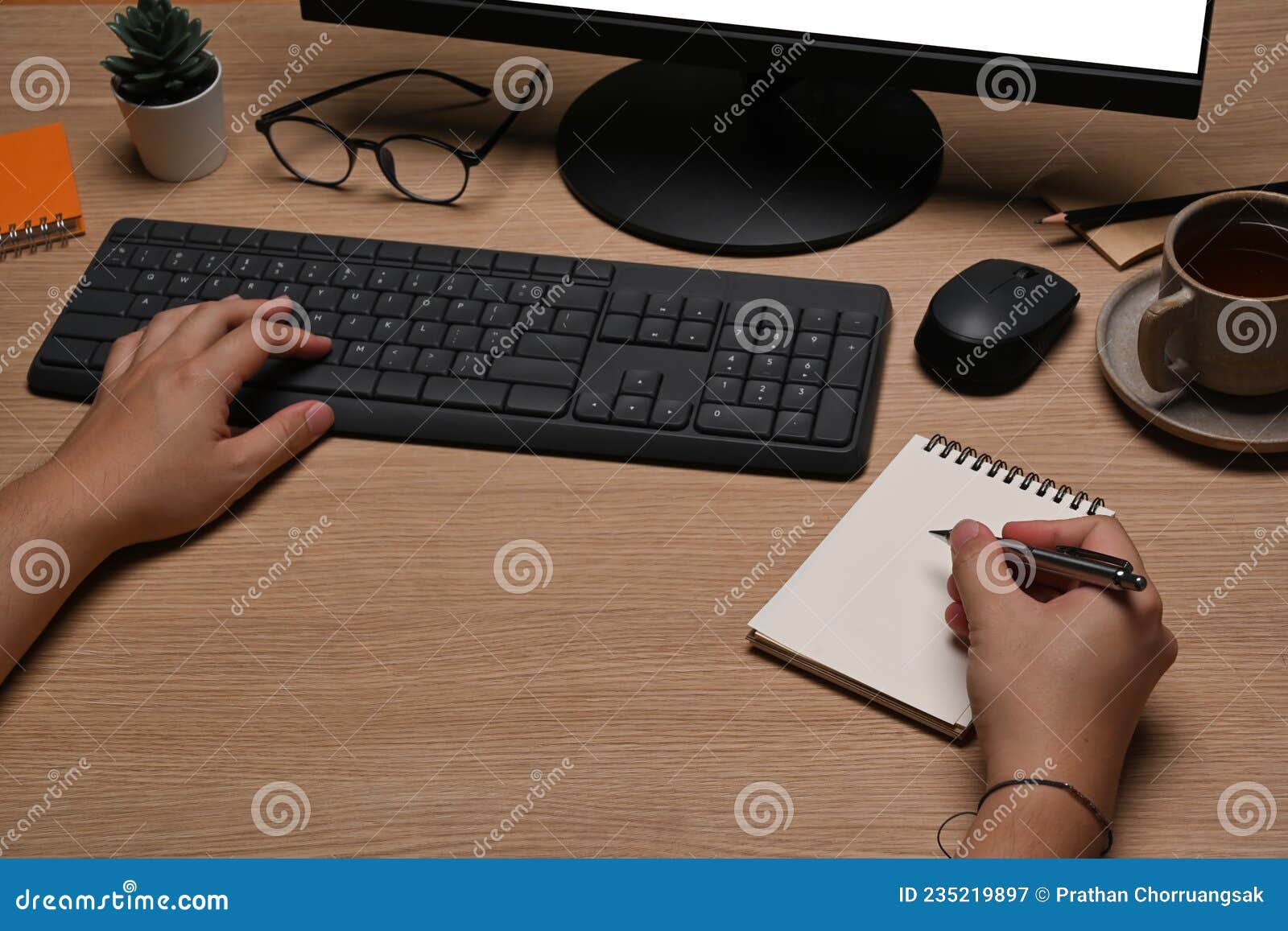 Man Making Notes on Notebook and Working with Computer. Stock Image ...
