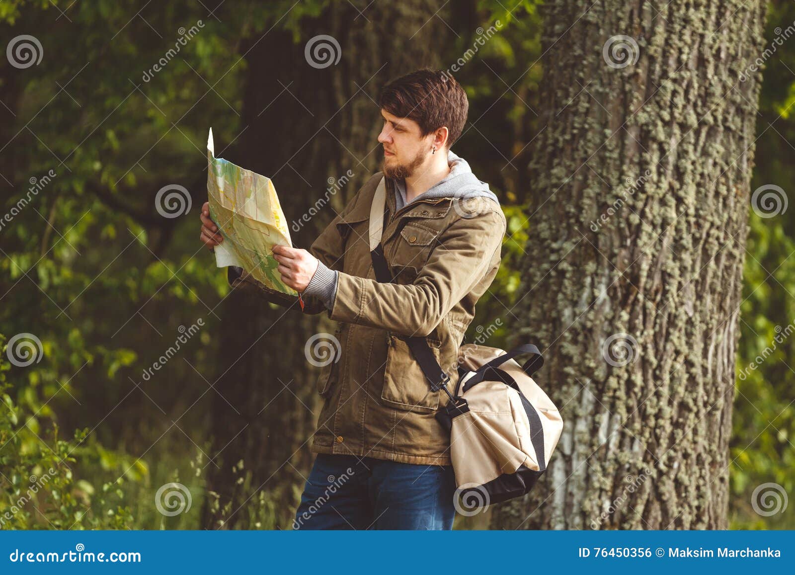 Man with Map and Bag in Hand Walking on a Roadside Stock Photo - Image ...