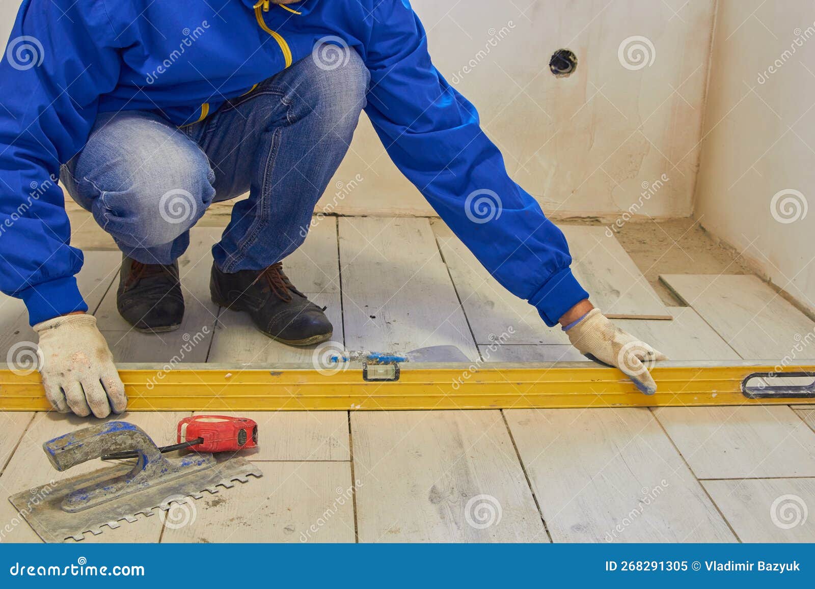 A Man Measures the Level of Laid Tiles,the Builder Measures the Level ...