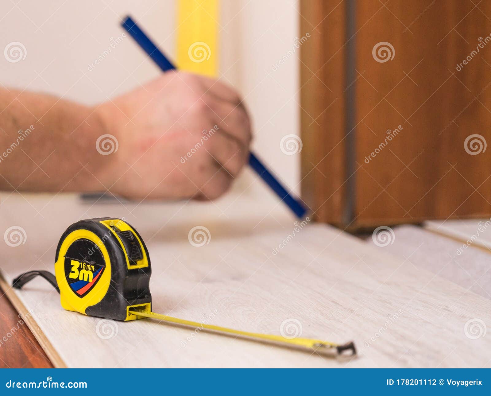 Man measuring floor panels stock photo. Image of indoor - 178201112