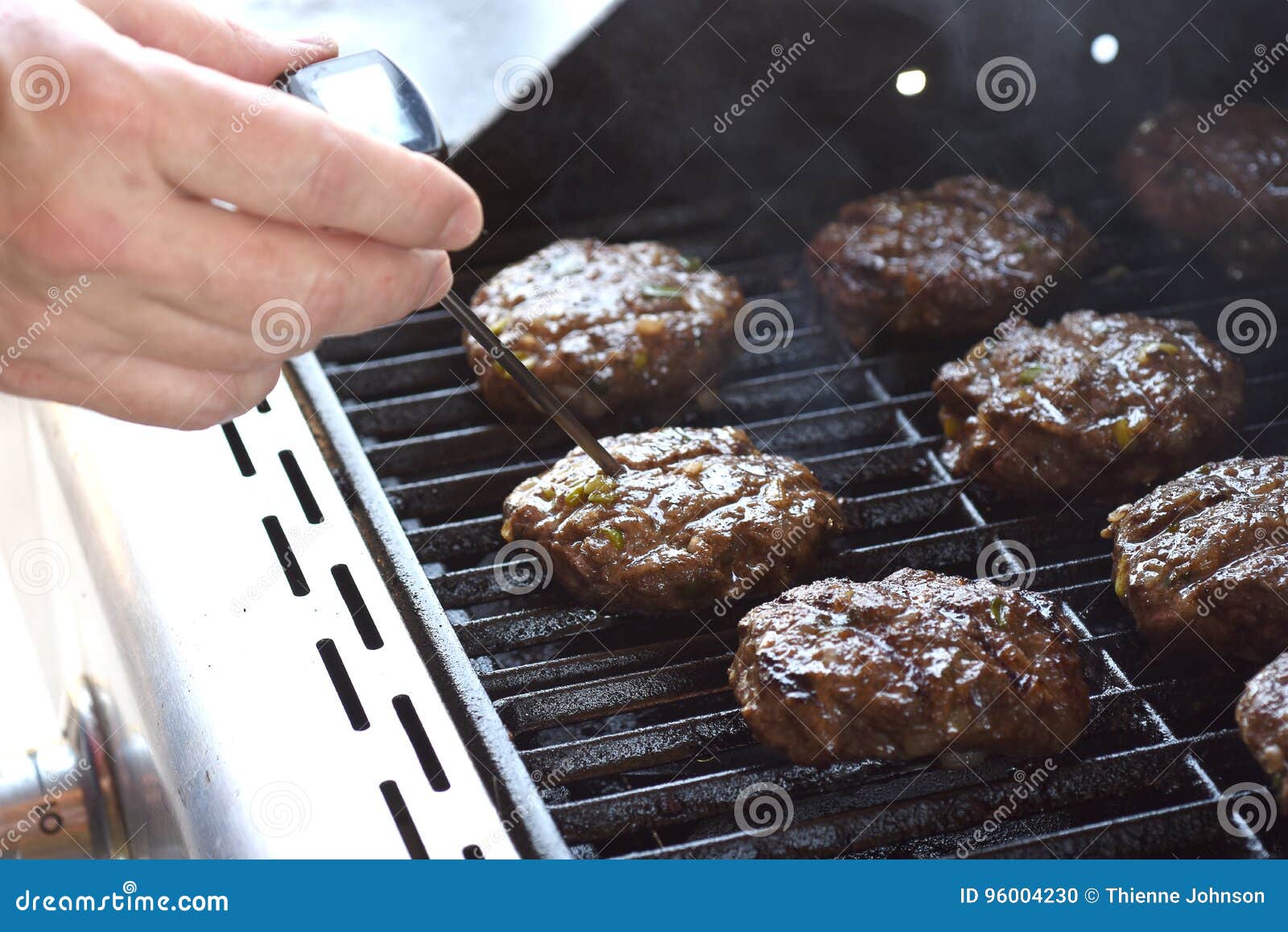 Man Measuring Temperature of Burger Cooking on the Grill Stock Photo ...