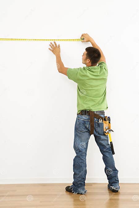 Man measuring wall. stock image. Image of construction - 3532979