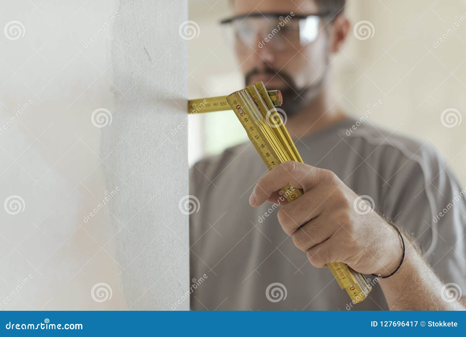 Man Measuring a Wall Using a Folding Ruler Stock Image - Image of ...