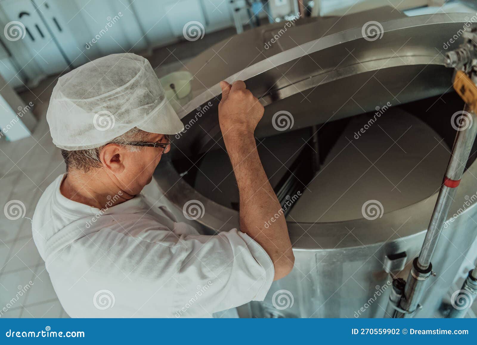 Man Mixing Milk in the Stainless Tank during the Fermentation Process ...