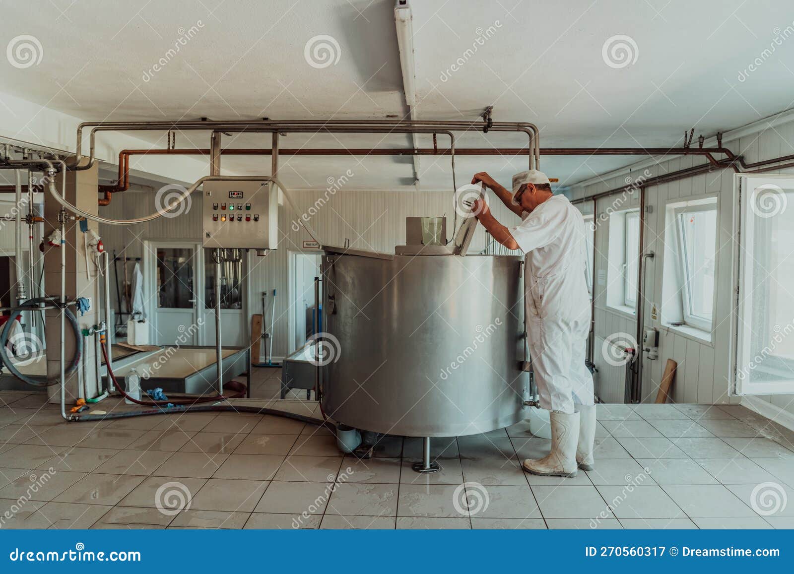 Man Mixing Milk in the Stainless Tank during the Fermentation Process ...