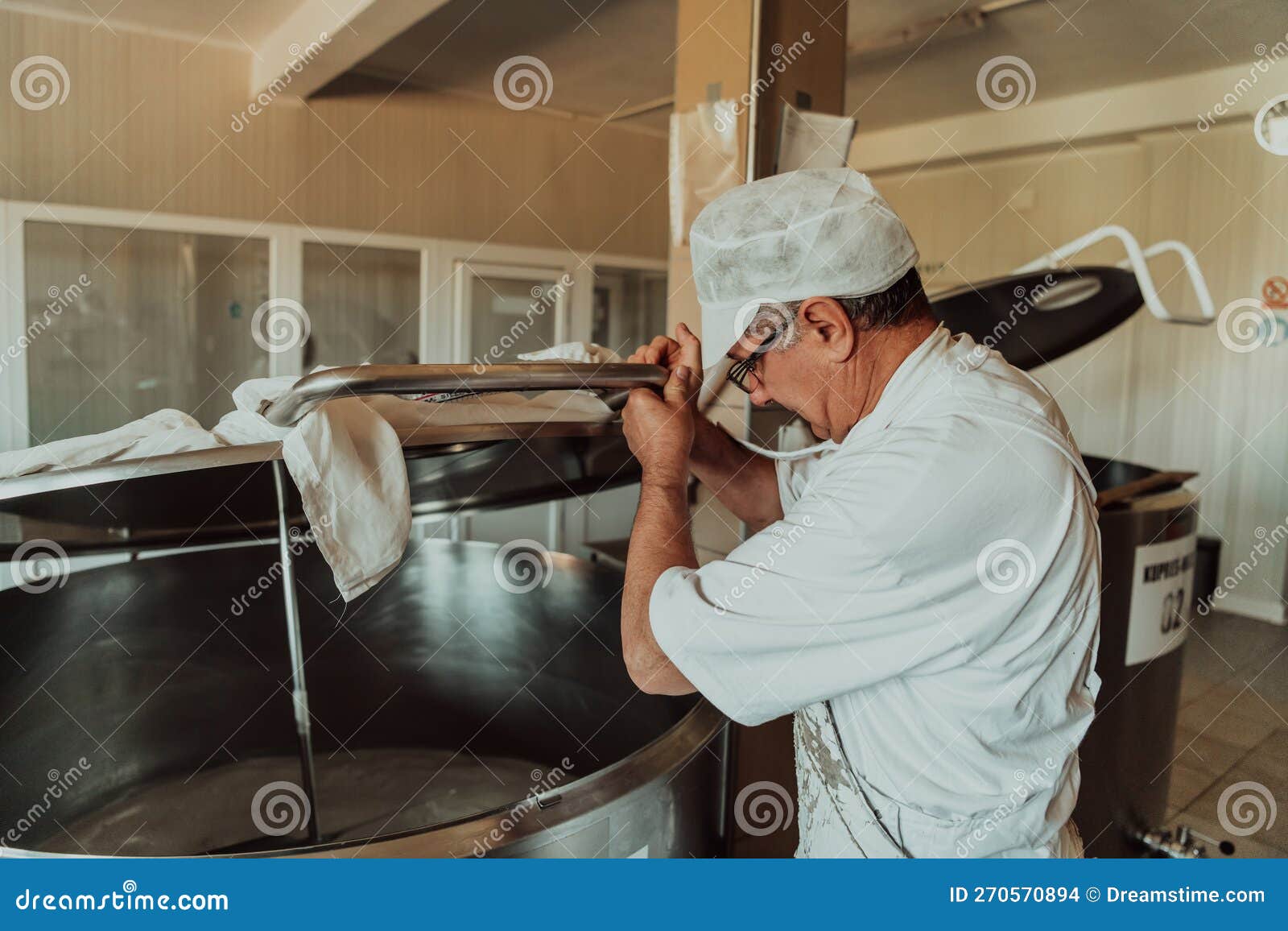Man Mixing Milk in the Stainless Tank during the Fermentation Process ...