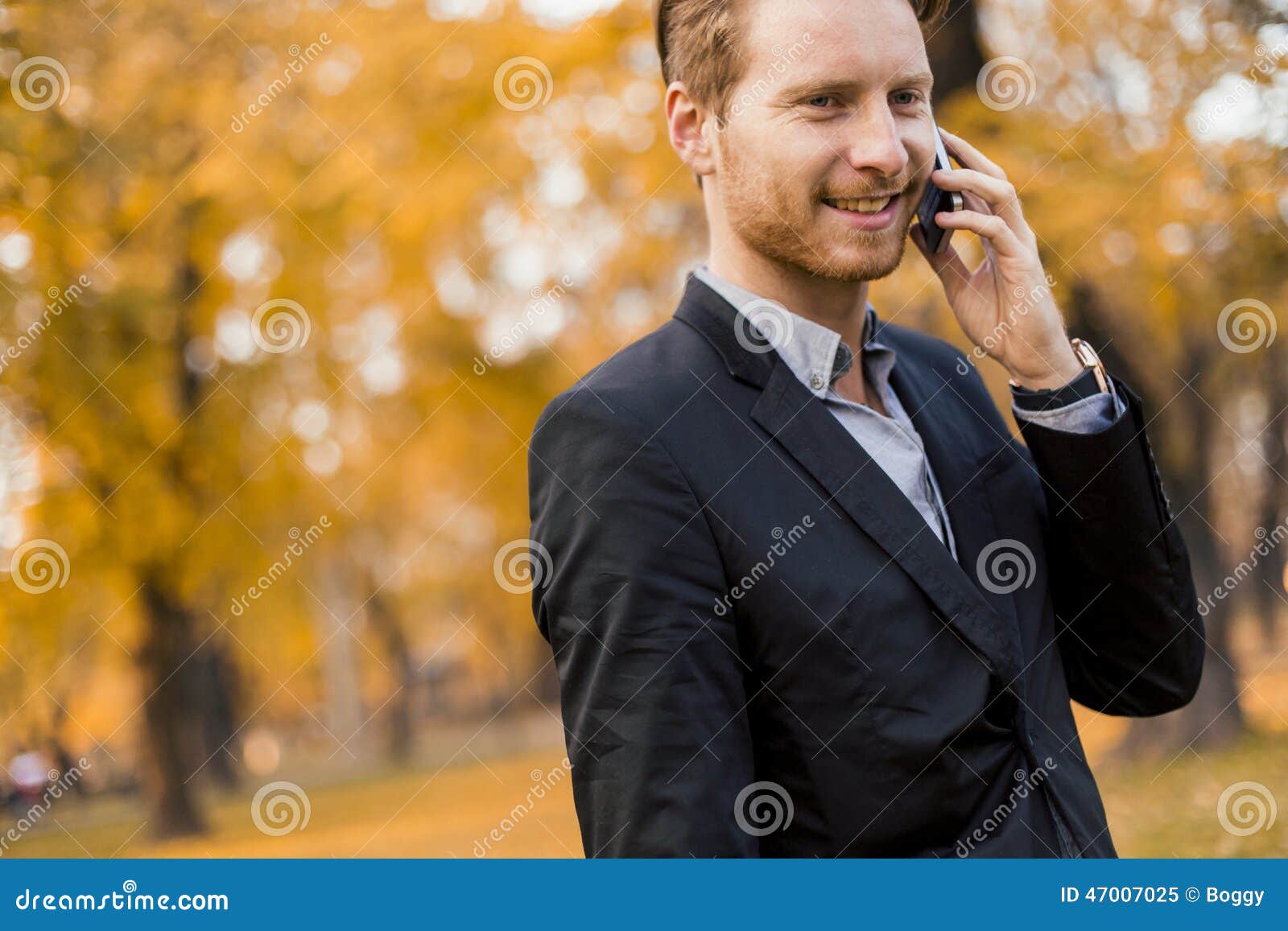 Man with Mobile Phone in the Autumn Park Stock Image - Image of looking ...