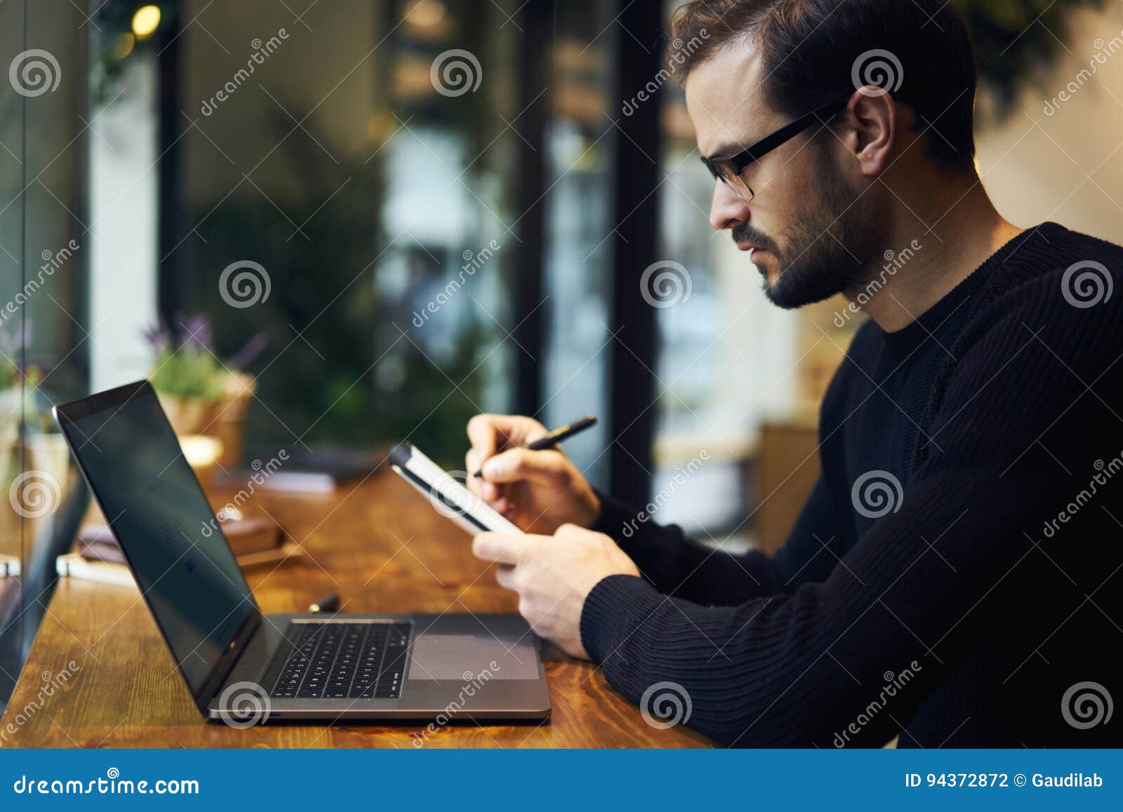 Man with Mobile Phone Working in Coffee Shop Using Laptop Computer and ...