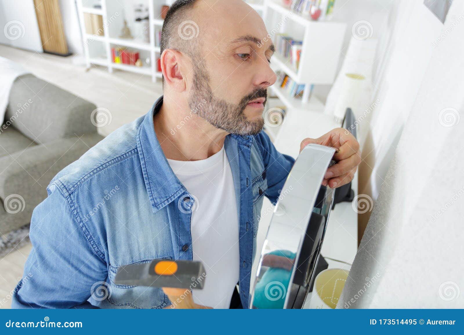 Man mounting clock on wall stock image. Image of house - 173514495