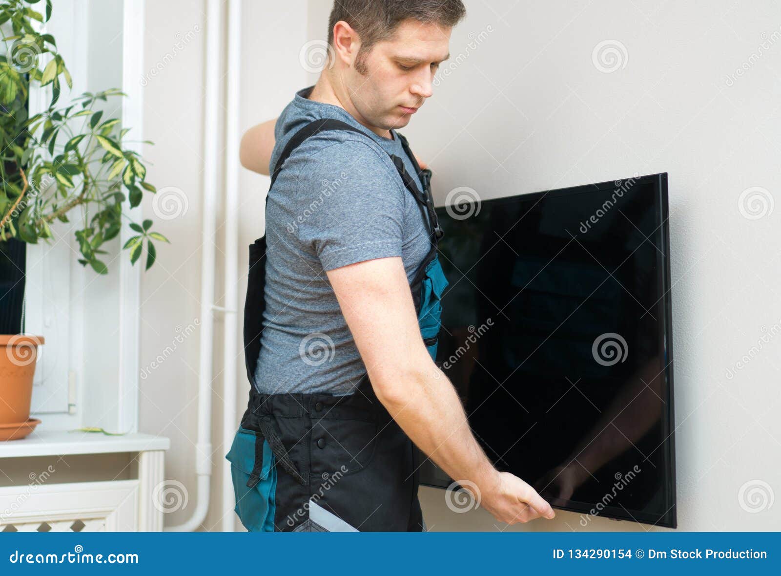 Man mounting TV stock photo. Image of professional, flat - 134290154
