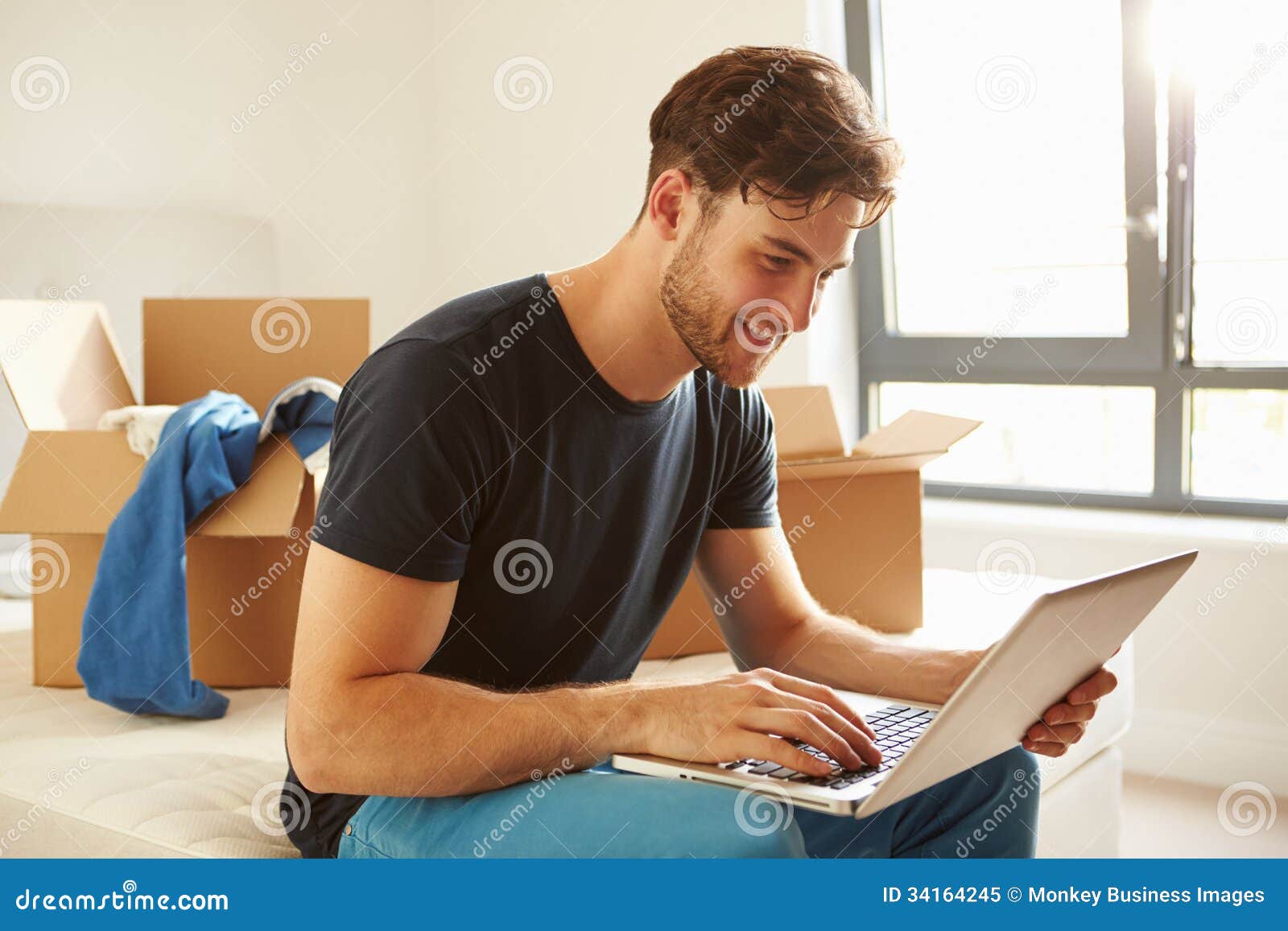 Man Moving into New Home Using Laptop Computer Stock Image - Image of ...