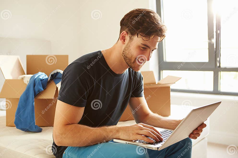 Man Moving into New Home Using Laptop Computer Stock Image - Image of ...