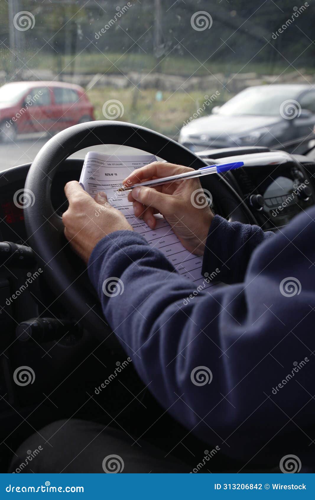 Man Multitasking, Holding a Clipboard and Reading Papers while Driving ...