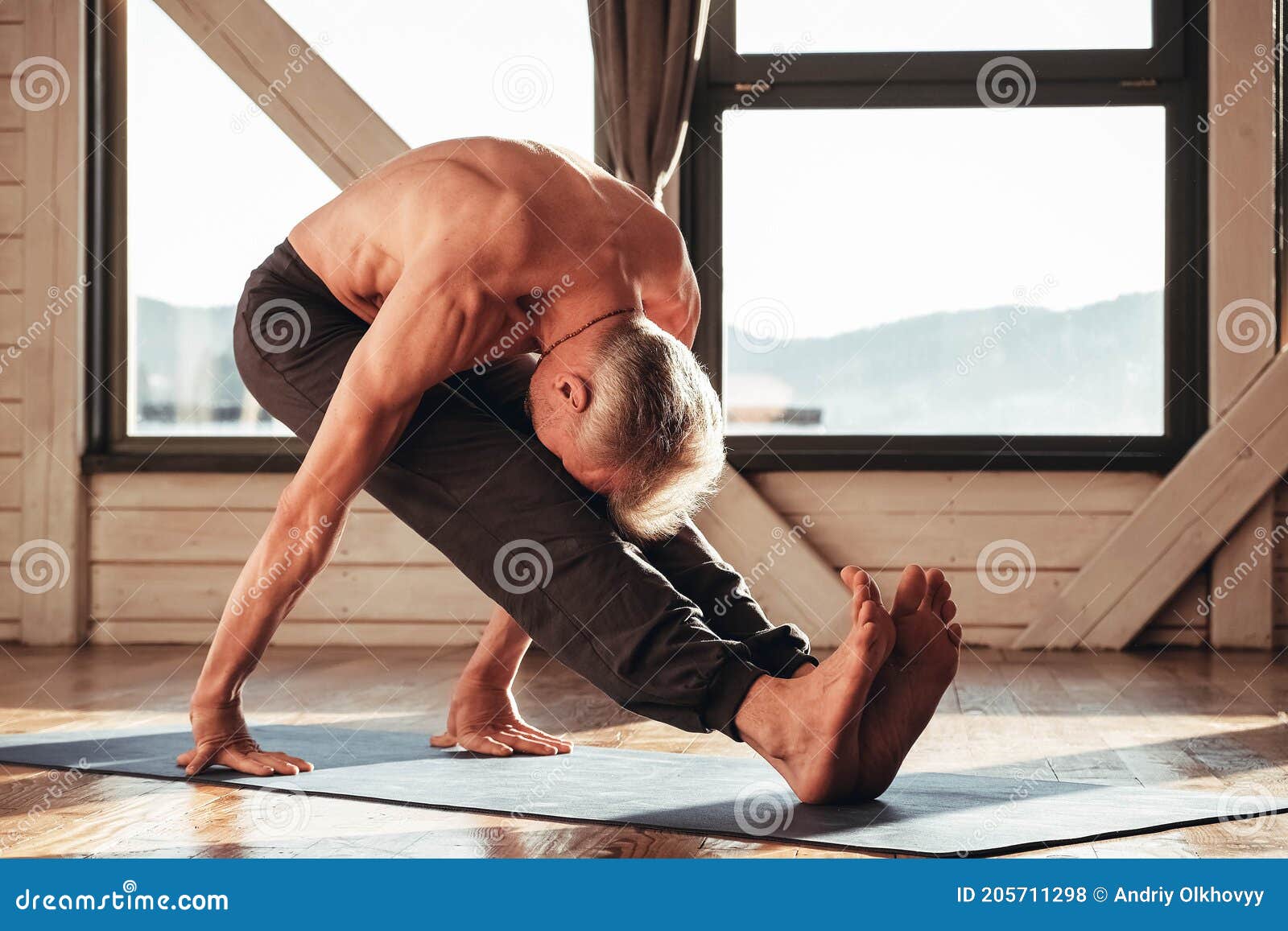 Man with a Naked Torso Practicing Yoga Training in Studio in Front of a ...