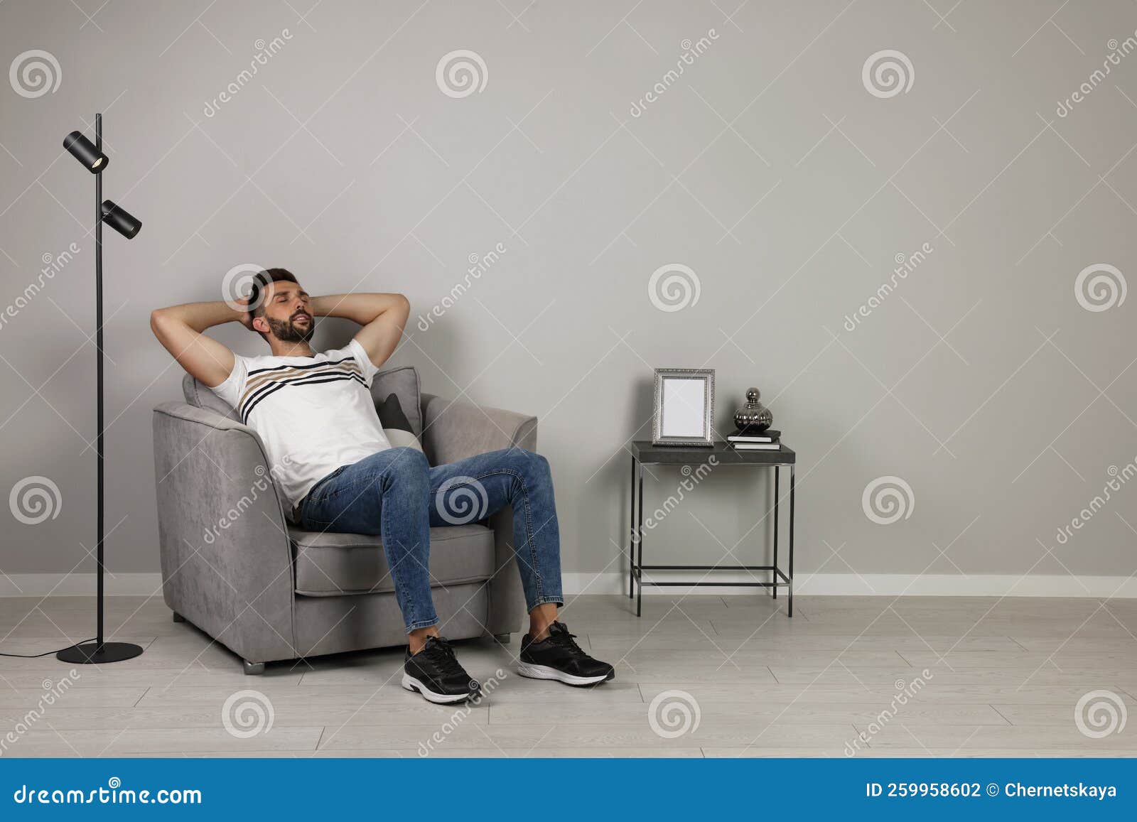 Man Napping in Armchair Near Gray Wall, Space for Text Stock Photo ...