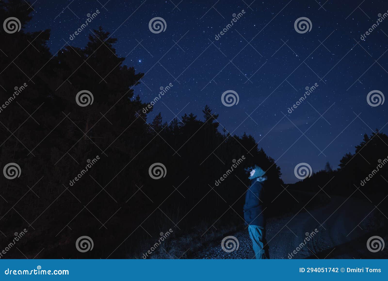 A Man with a Night Vision Device on His Head at Night in a Forest with ...