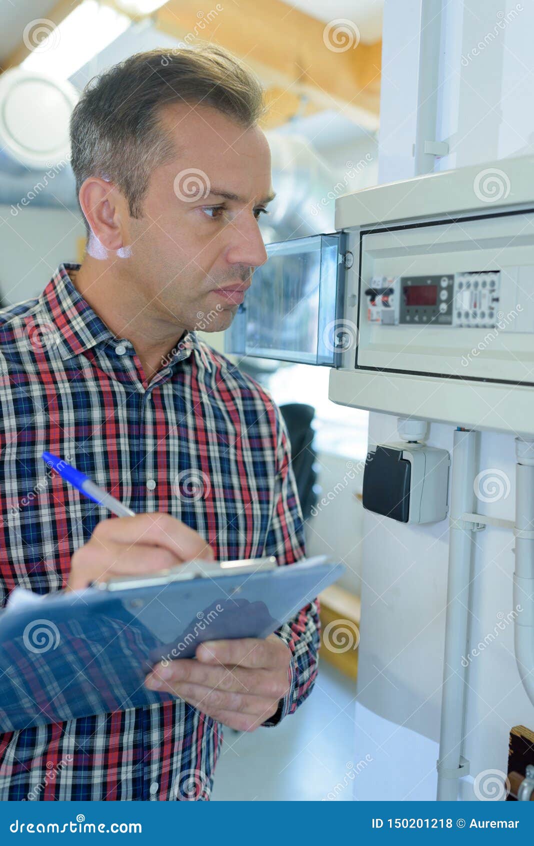 Man Noting Reading from Electricity Meter Onto Clipboard Stock Photo ...